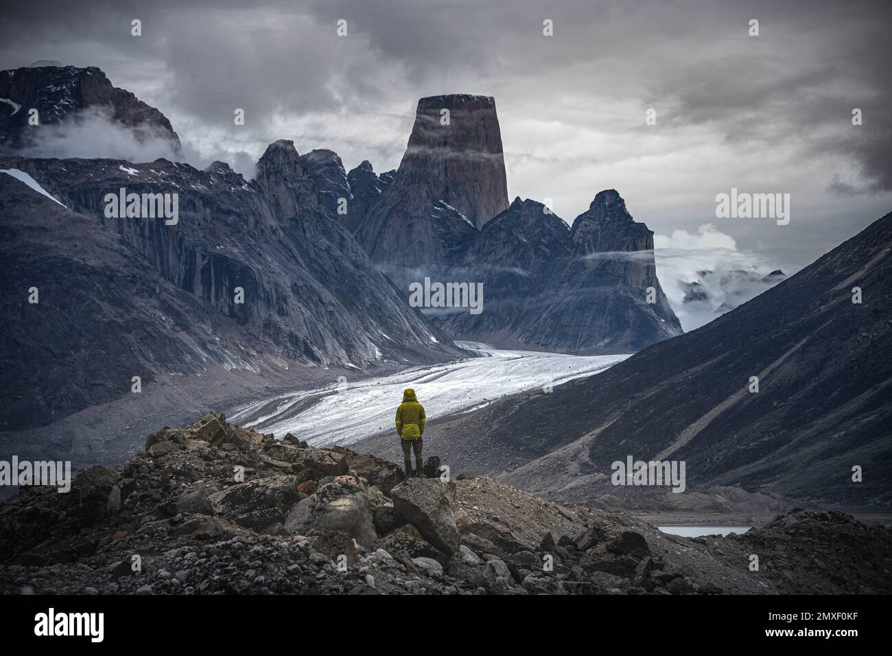 Hiker standing on the peack with Mount Asgard, Baffin Island on ...