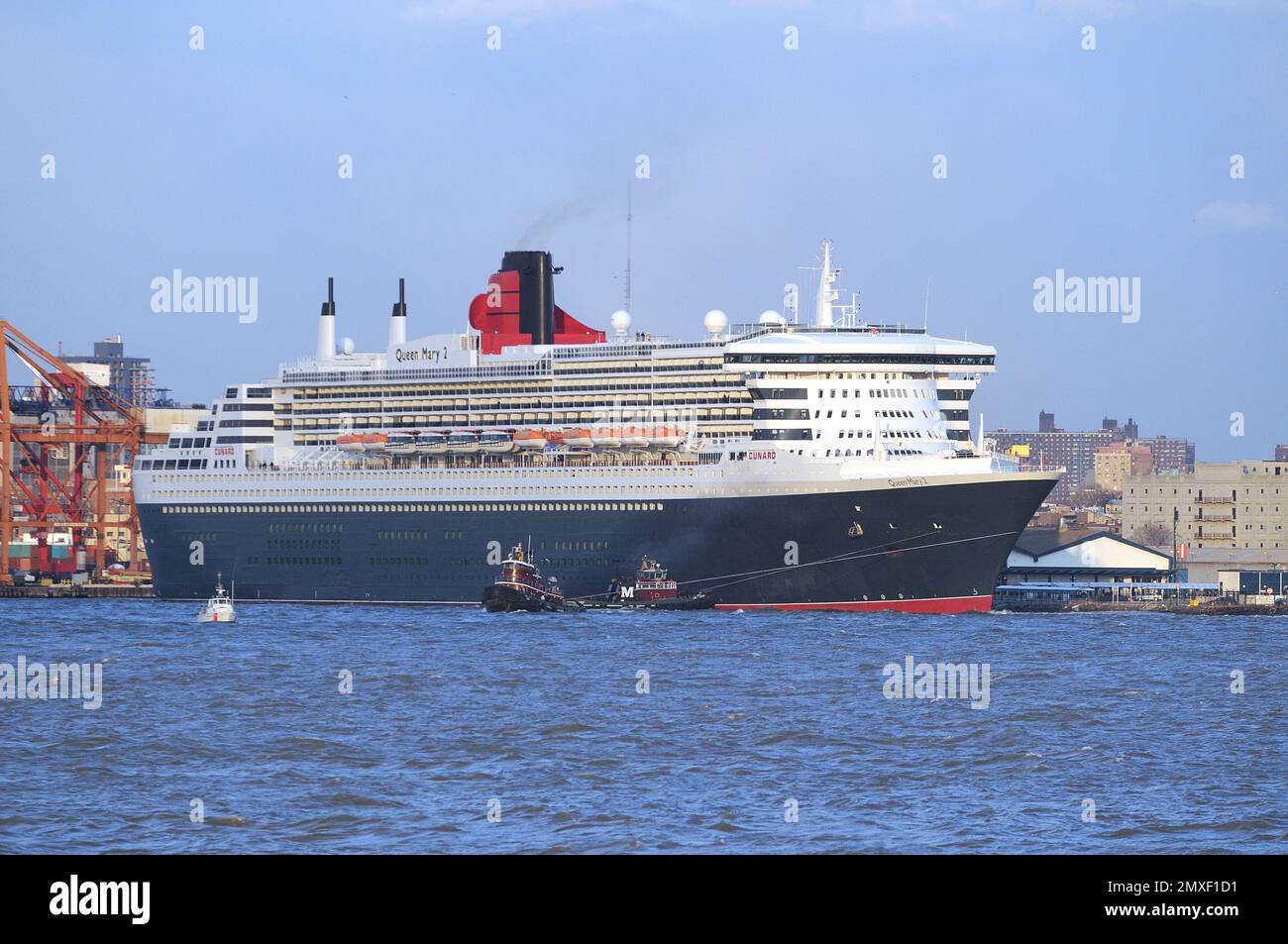 Queen Mary 2 luxury cruise ship docked at a port, surrounded by ...