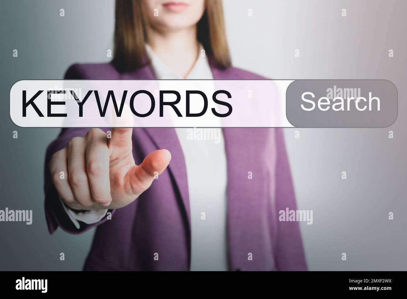Woman pointing at search bar with text KEYWORDS on light grey ...