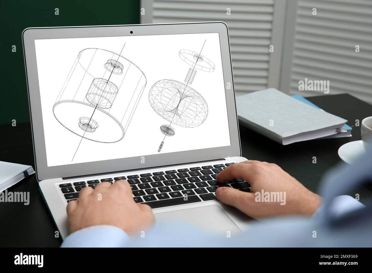 Male engineer working with 3d model of modern equipment on laptop in ...