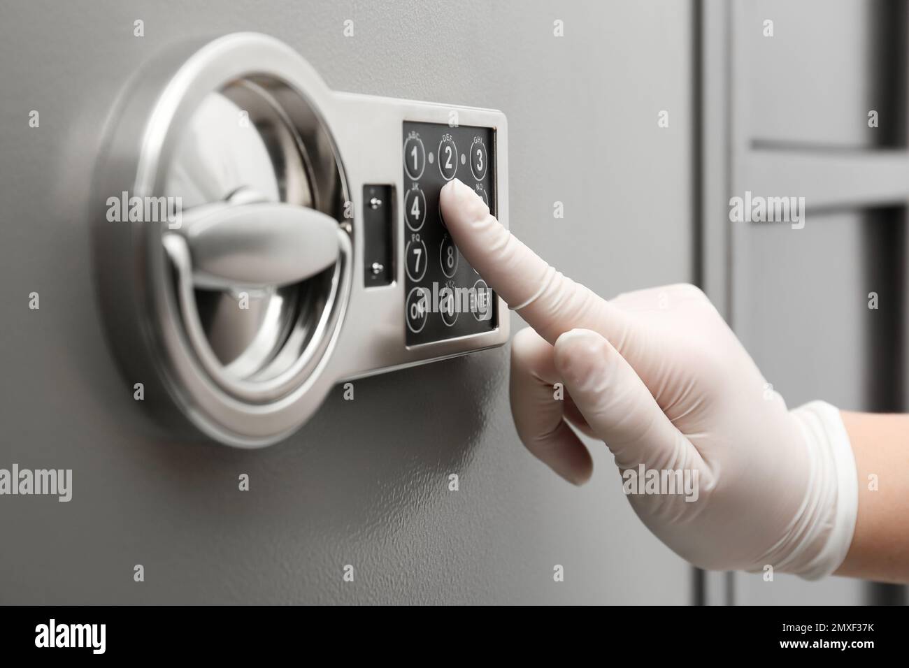 Woman in gloves entering code on keypad of modern safe, closeup Stock ...