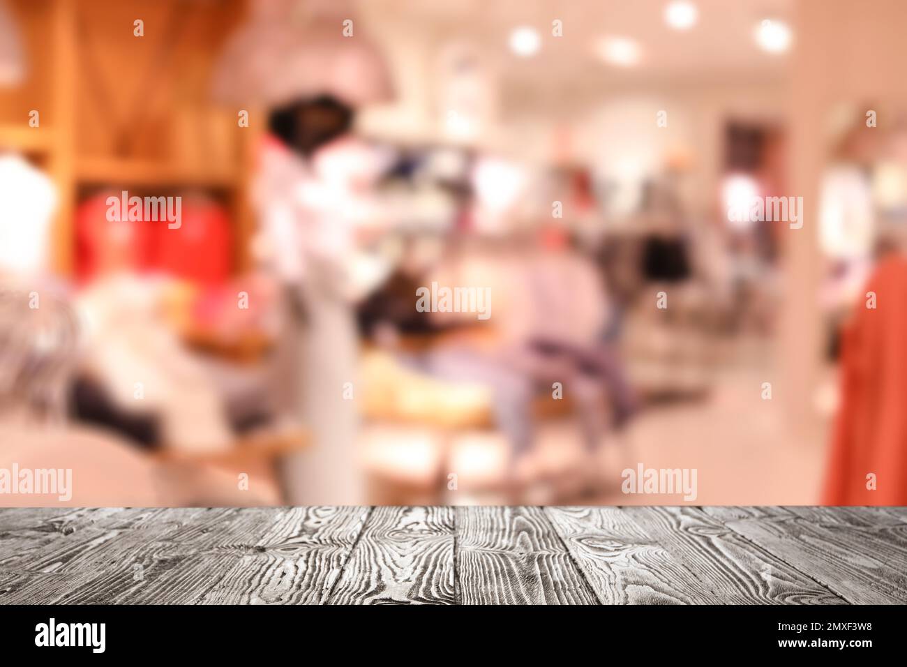 Empty wooden table and blurred view of store with modern clothes Stock ...