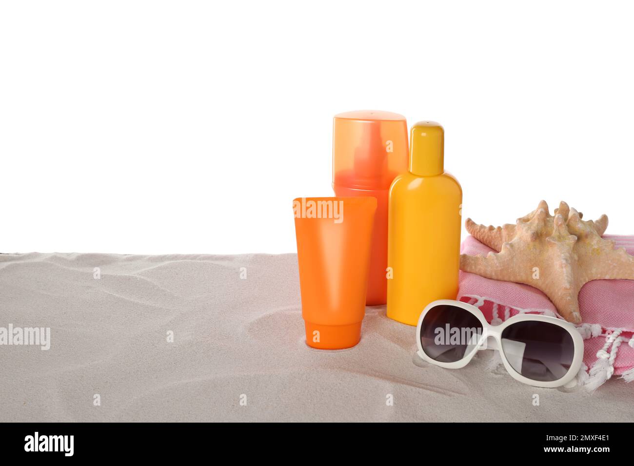 Composition with sun protection products on sand against white ...