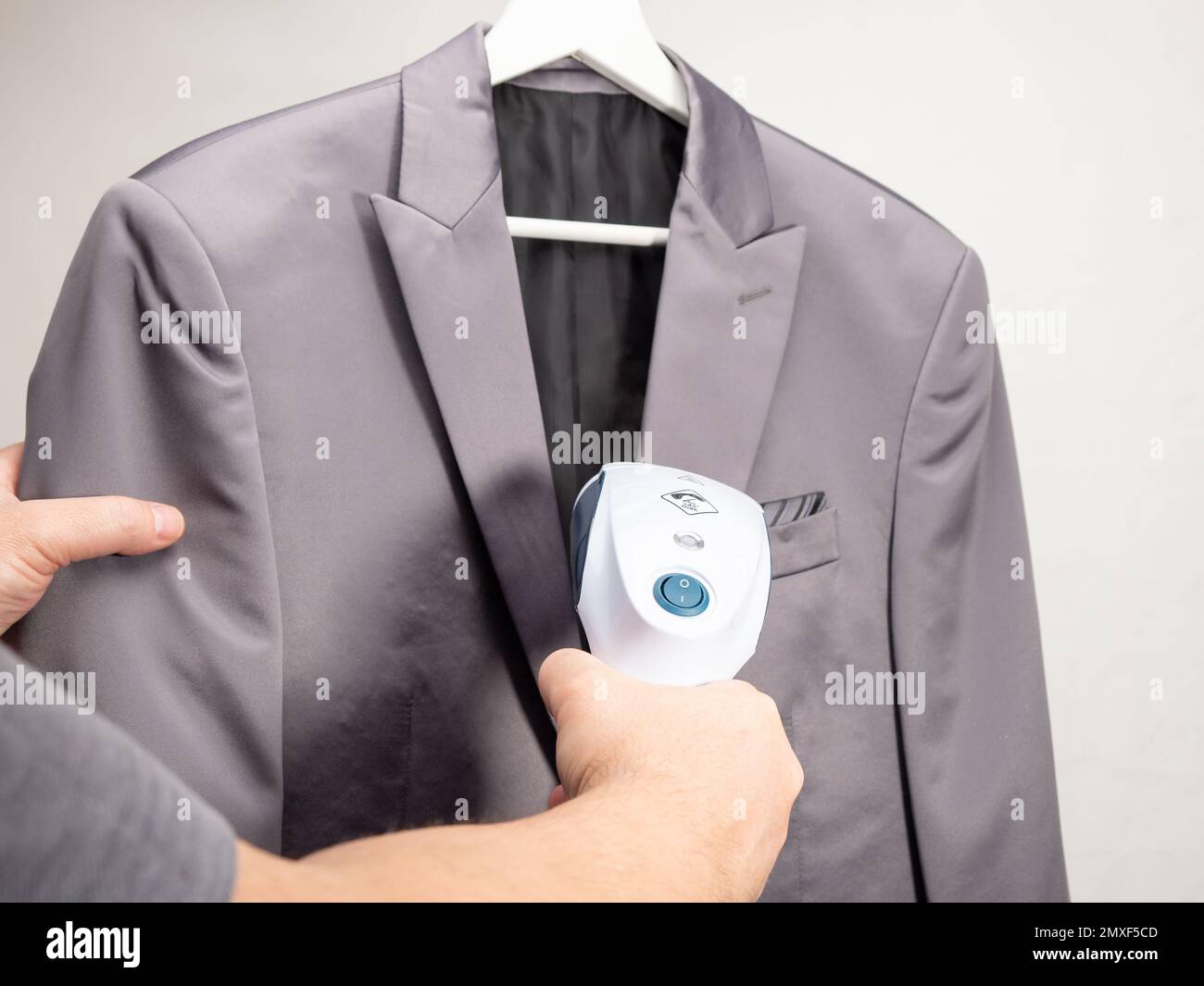 In hand Steamer for clothes. The suit is ironed with a portable iron ...