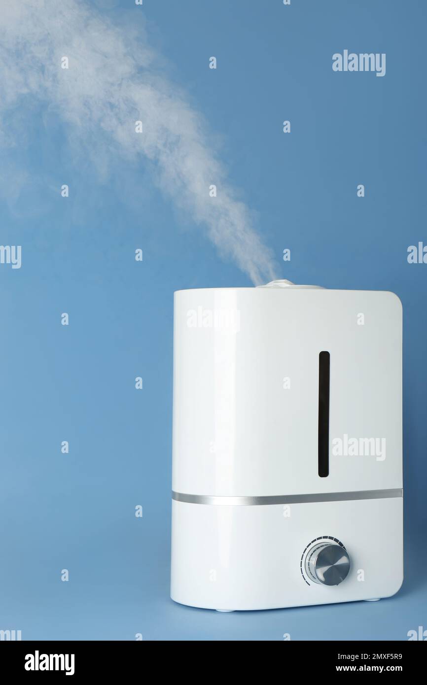 Modern air humidifier on light blue background Stock Photo - Alamy