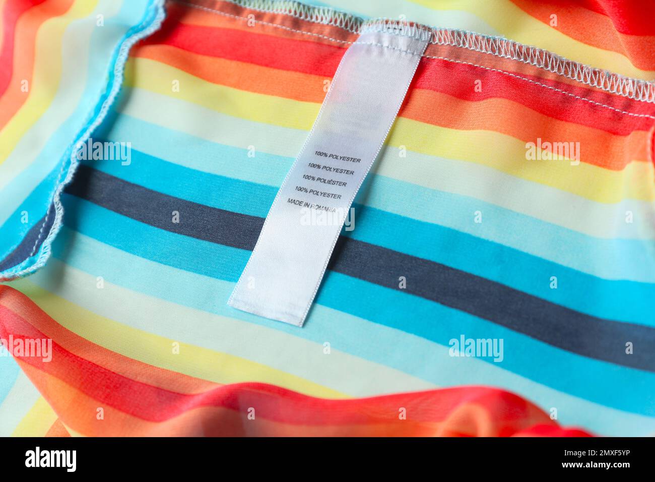 Clothing label with content information on colorful striped garment ...