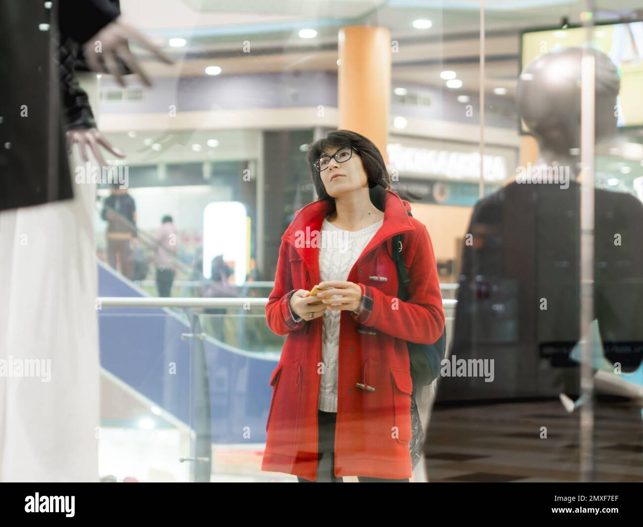 Woman looks on dummies in clothing store. Casual outfit hanging on ...
