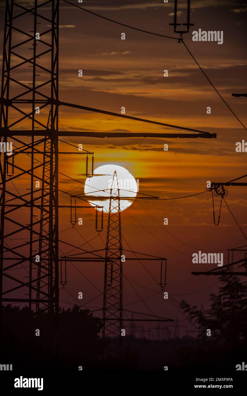Power poles in front of sunset in backlight Stock Photo - Alamy