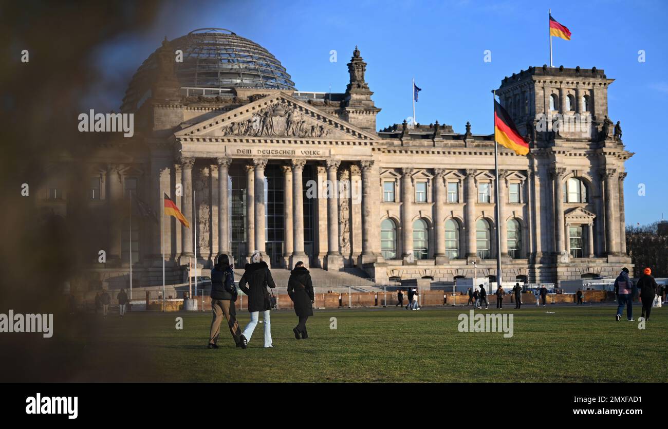 03 February 2023, Berlin: People walk across the lawn in front of the ...