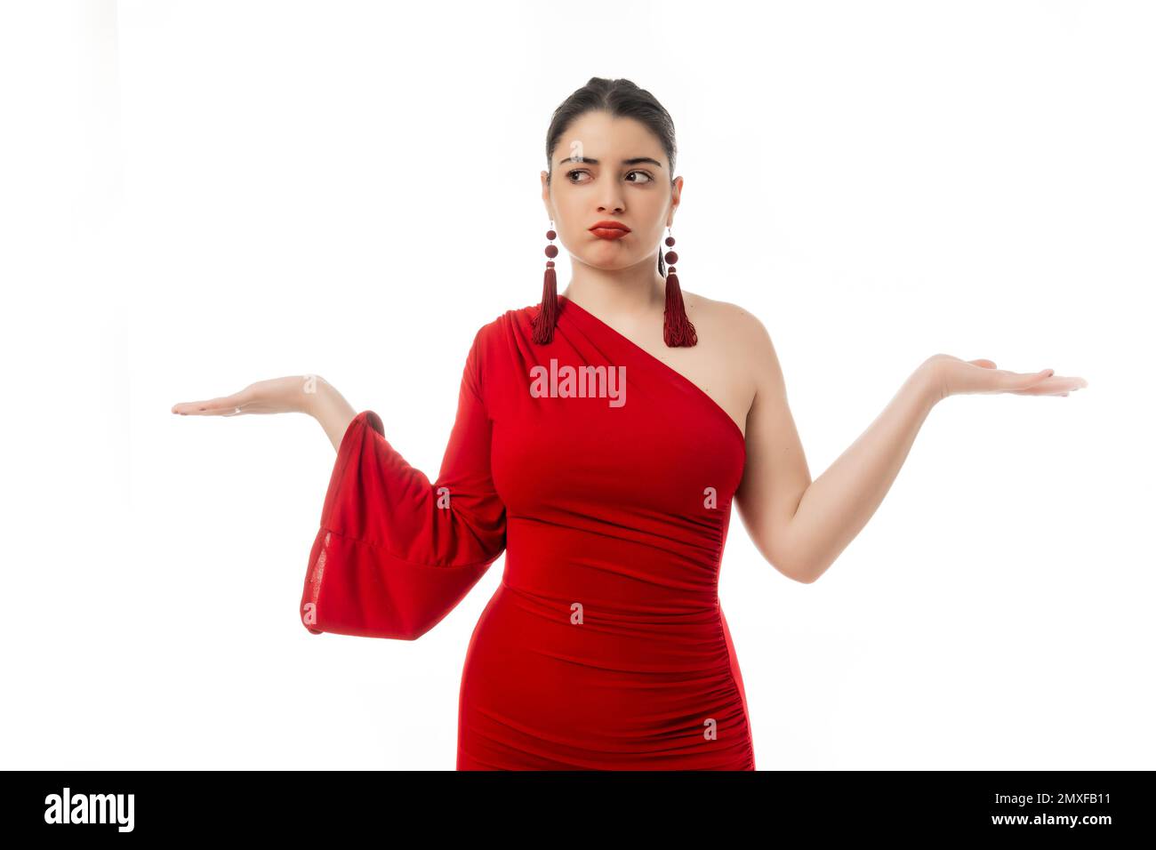 A confused attractive female in red dress posing on white background ...