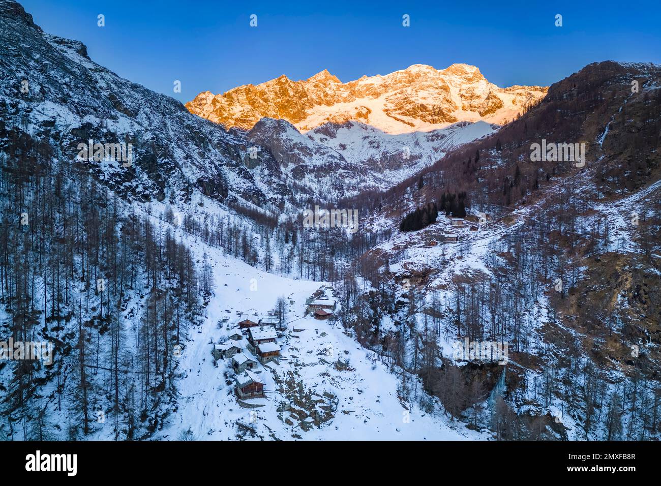 Aerial view of the Pastore Refuge and Monte Rosa at dawn in winter ...