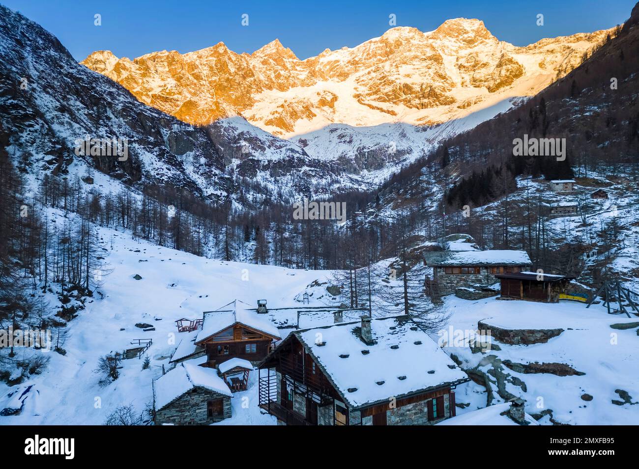 Aerial view of the Pastore Refuge and Monte Rosa at dawn in winter ...