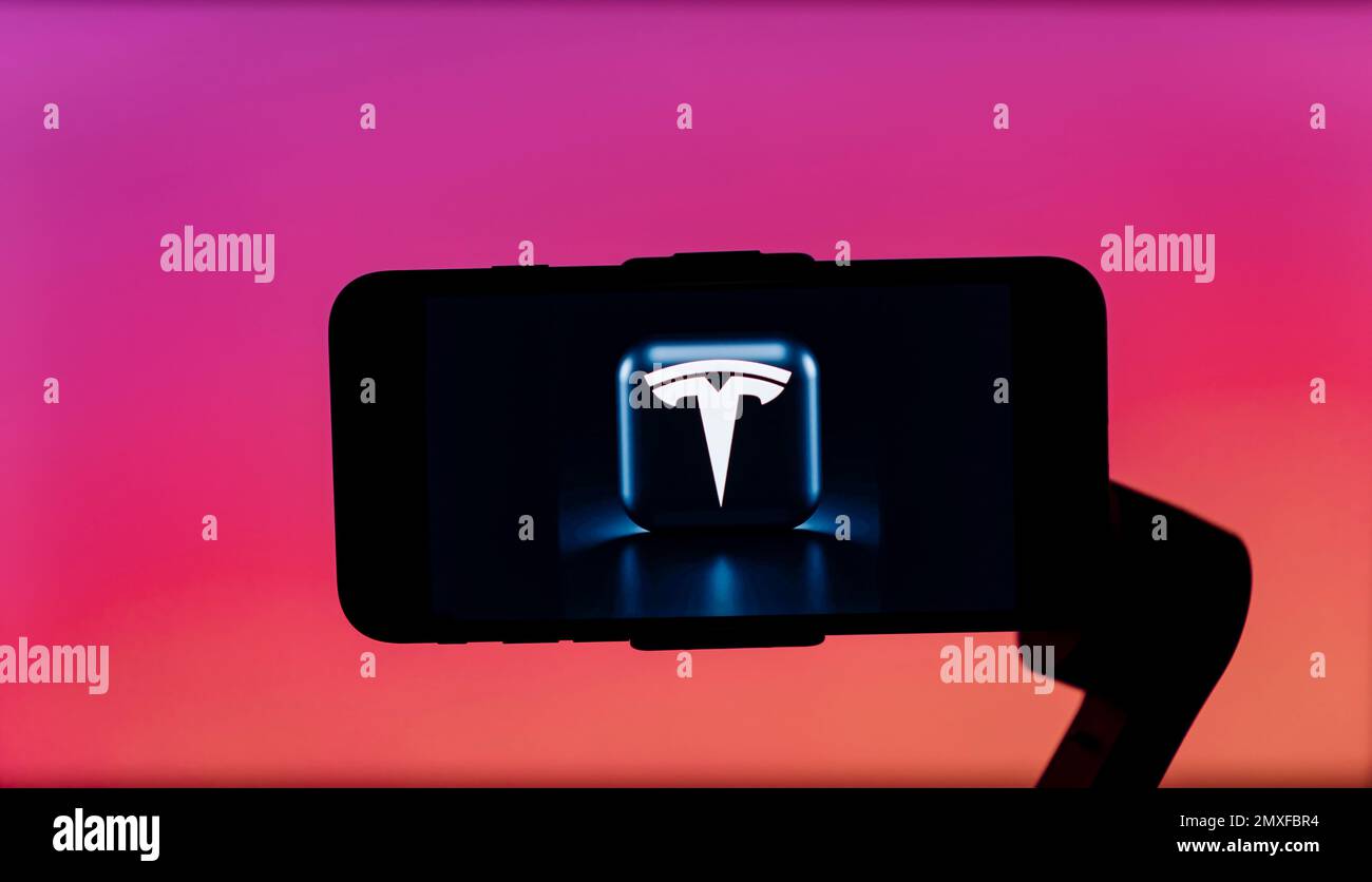 In this photo illustration, the Tesla logo is seen displayed on a ...