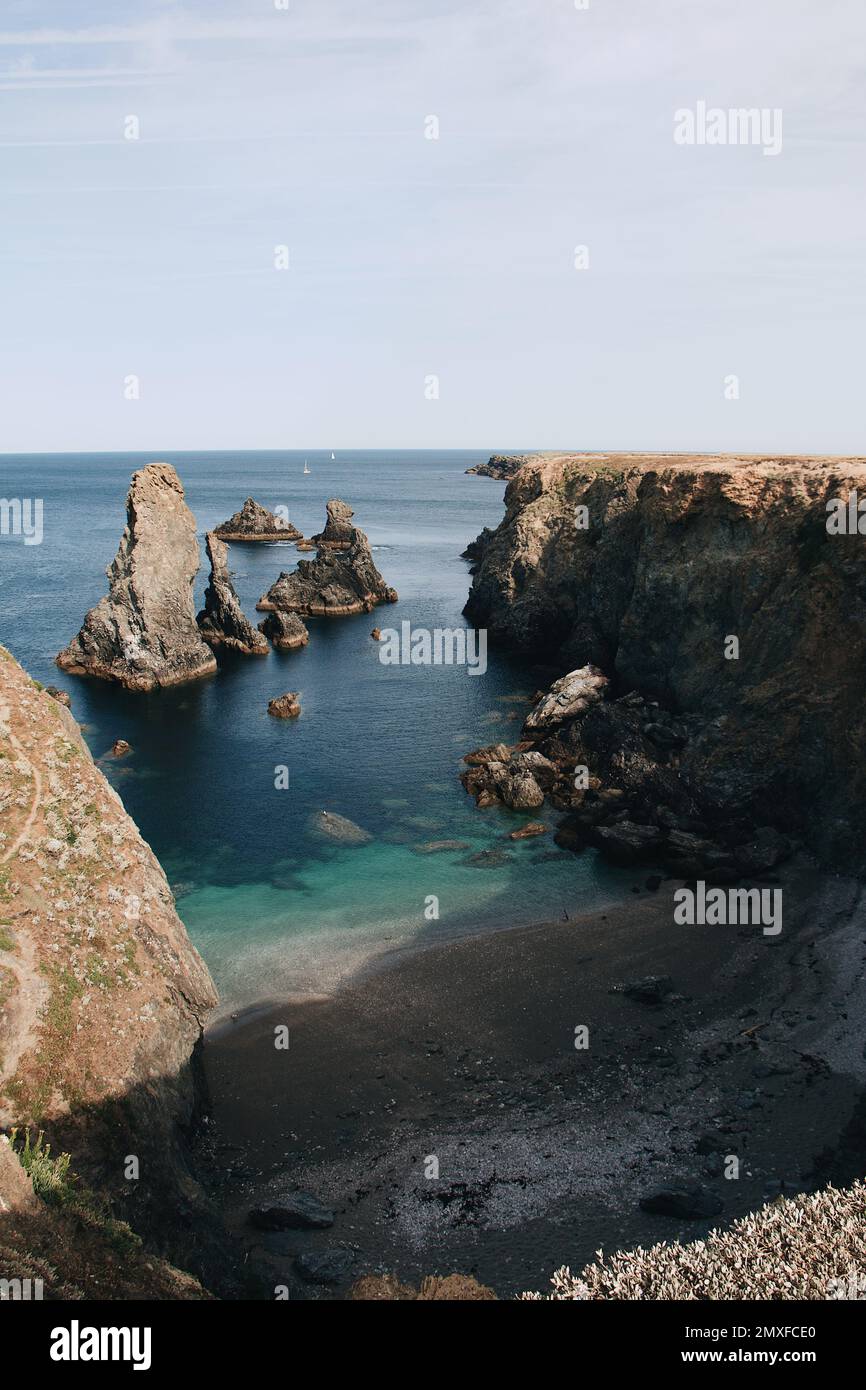 A vertical aerial view of huge rock pieces in the ocean in daylight ...