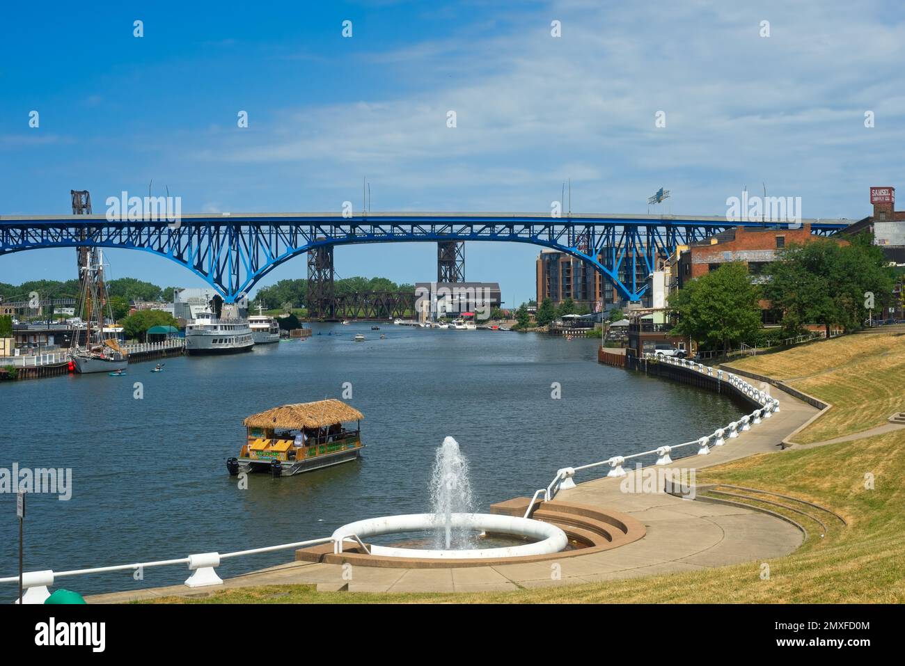 A thatch-covered group tour boat run by CLE Tiki Barge motors past the ...