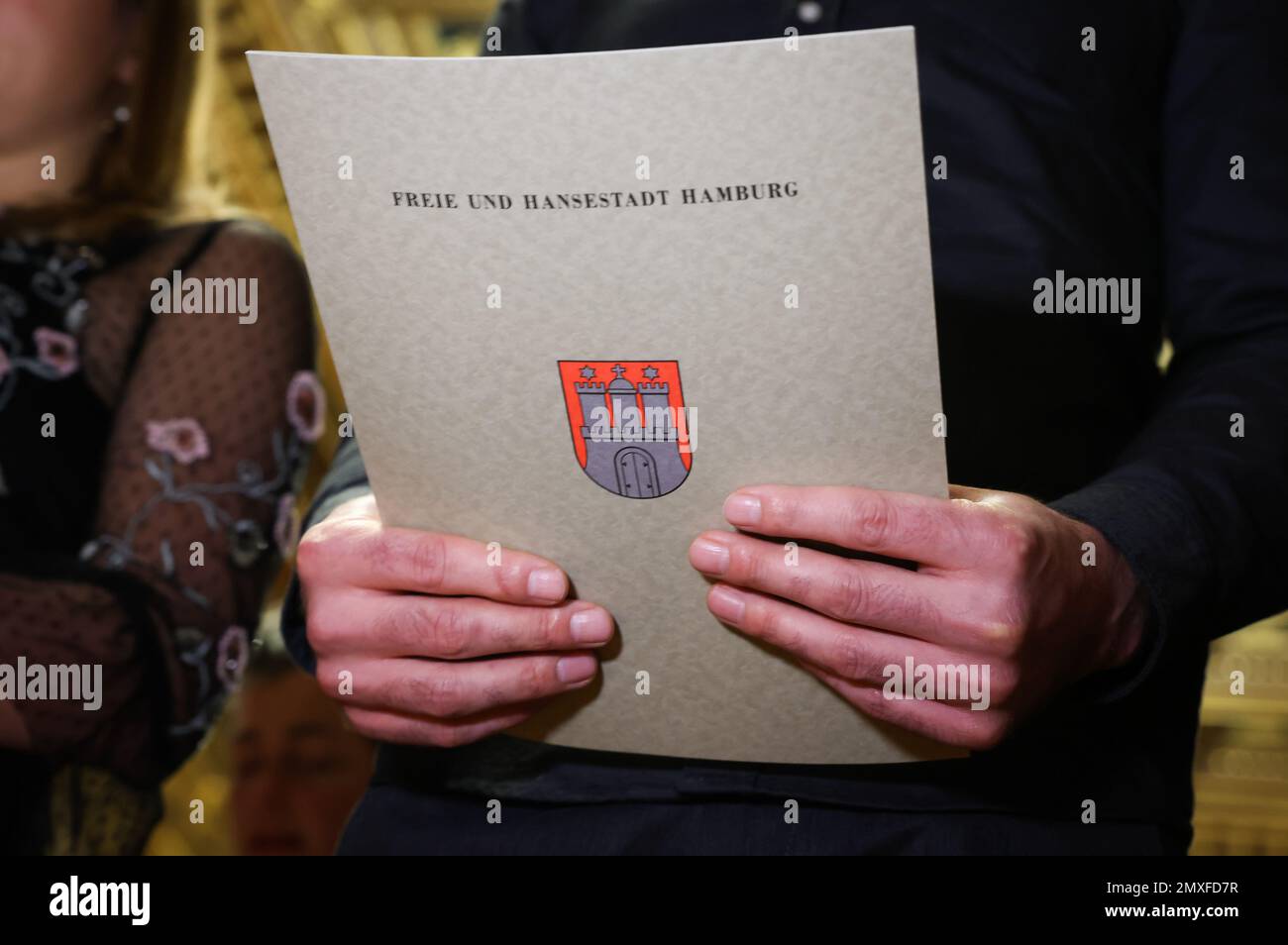 Hamburg, Germany. 03rd Feb, 2023. A new citizen holds his certificate ...