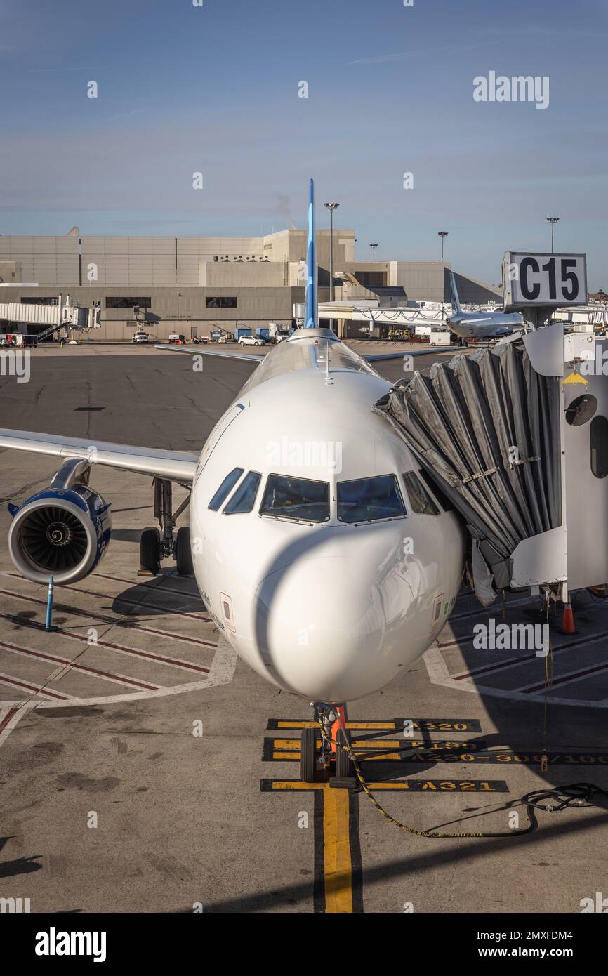 A vertical shot of an airplane connected to the jet bridge Stock Photo ...