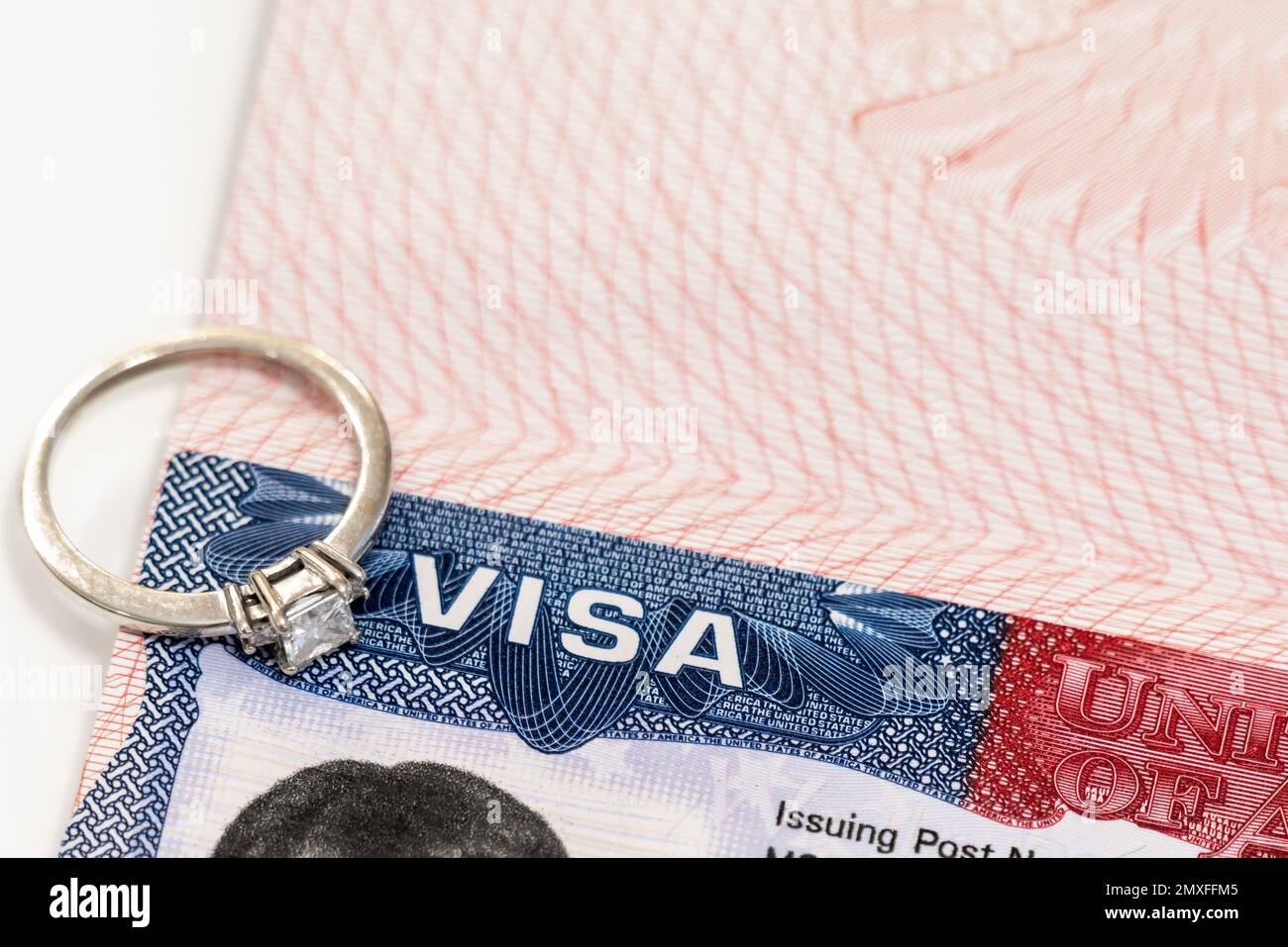Engagement ring on top of US entry visa sticker in a passport ...