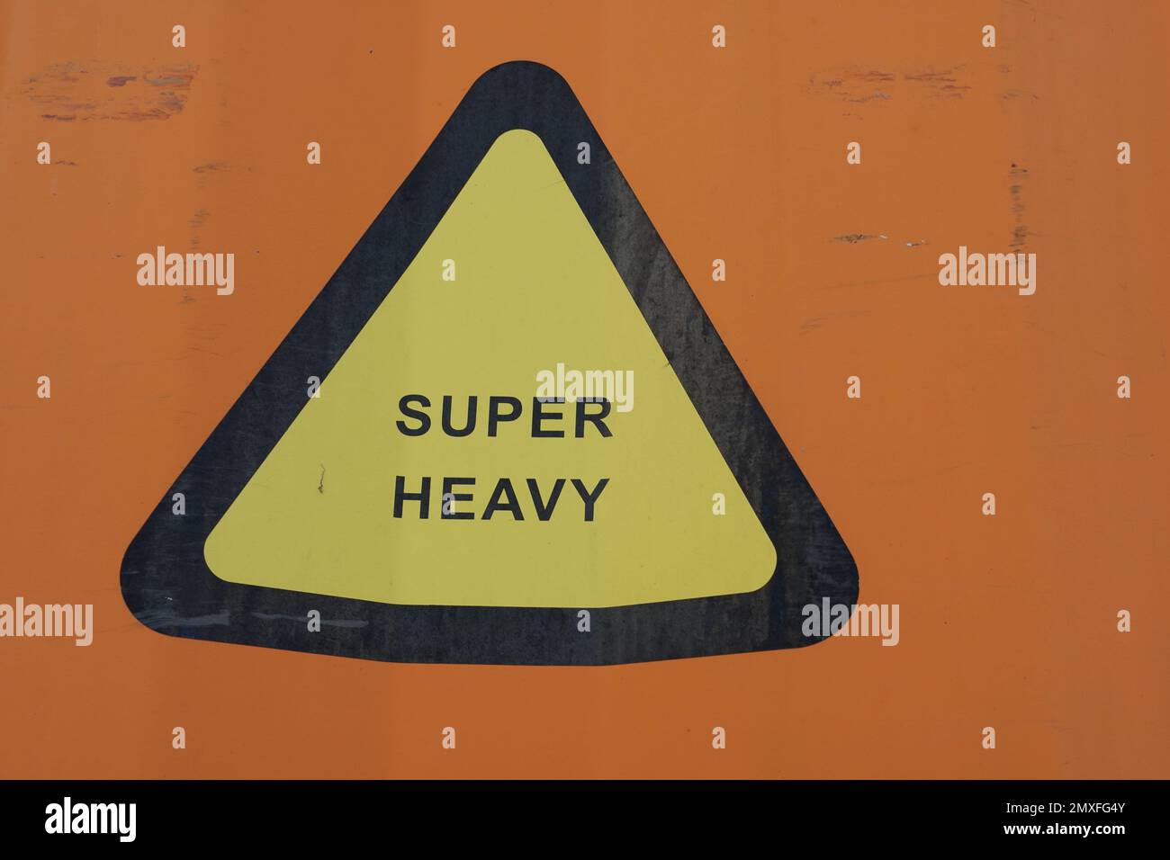 Label super heavy in shape of yellow triangle with black border or rim ...