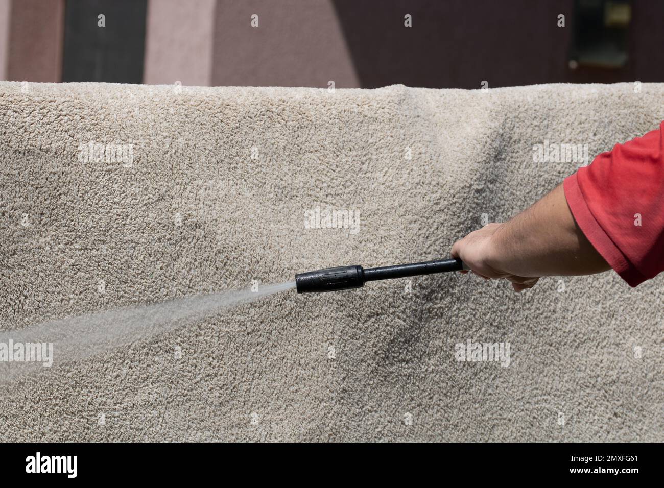 Washing carpets with high pressure washer. Cleaning the carpet with a ...