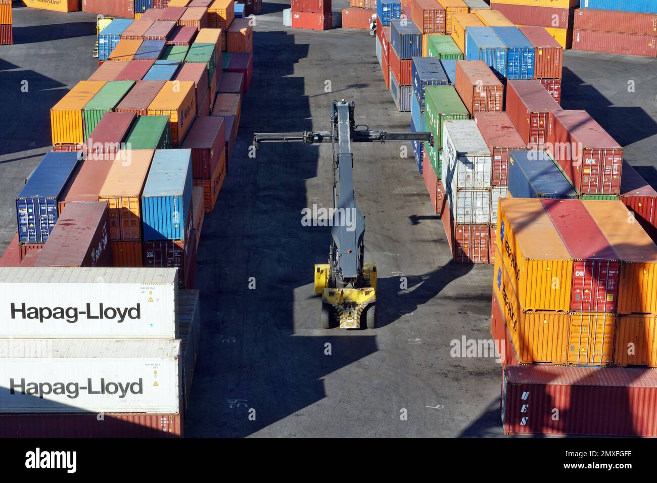 Reach stacker of yellow colour with black top pick spreader for laden ...