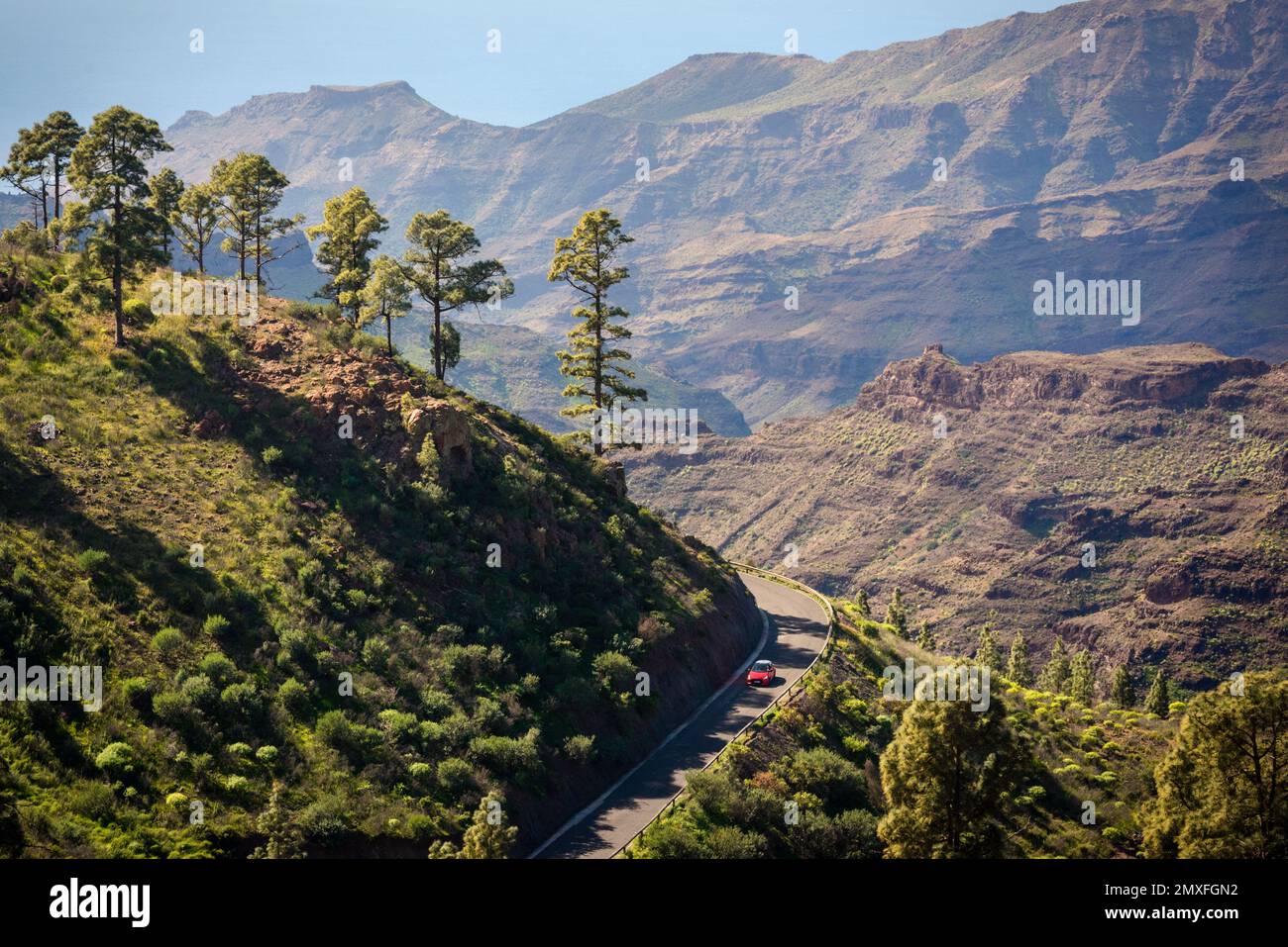 Red car driving on the road to Roque Nublo Rural Park, Gran Canary ...