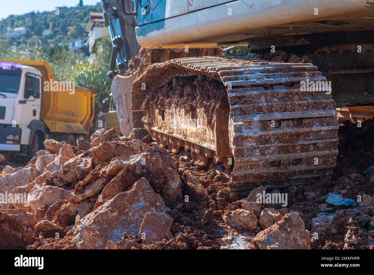 Heavy machinery works at the construction site. Clearing rocky soil for ...