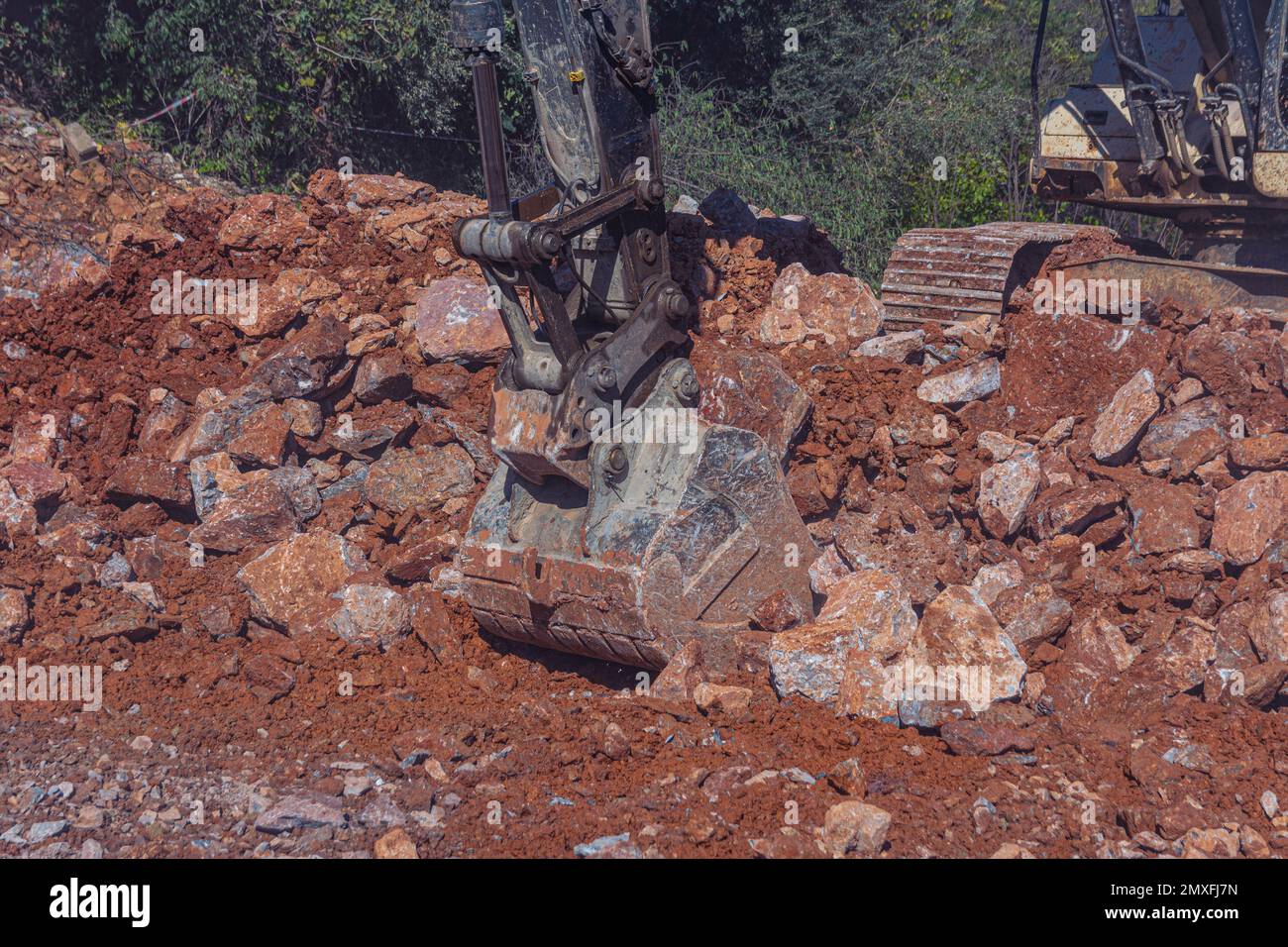 Heavy machinery works at the construction site. Clearing rocky soil for ...