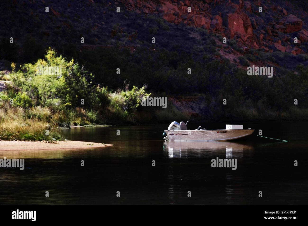 An empty small boat by the shore under the shadow of seaside mountain ...