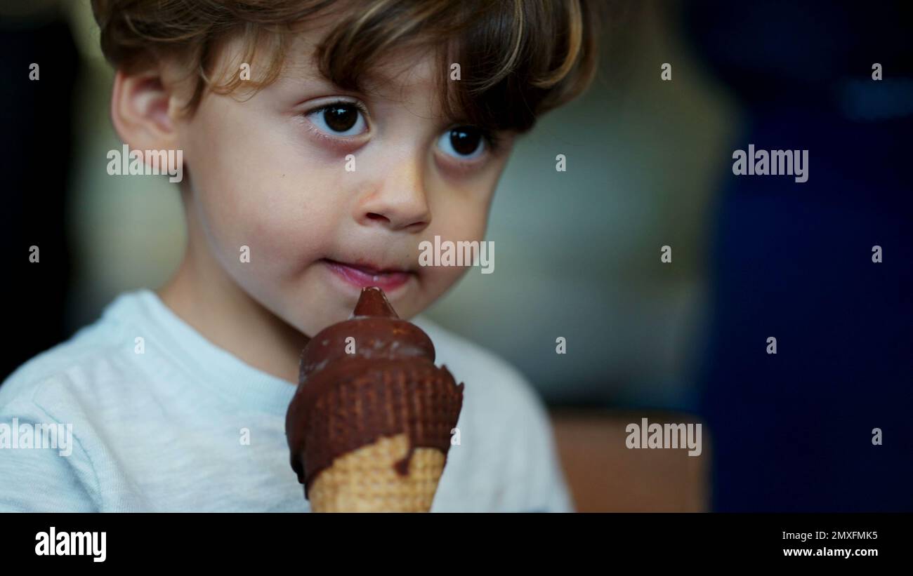 Child eating chocolate ice cream candid little boy eats sweet dessert ...