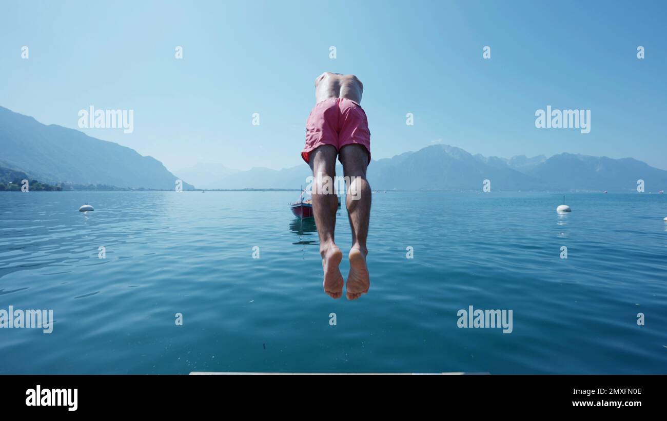 Man diving into lake person running on pier and dives into water Stock ...