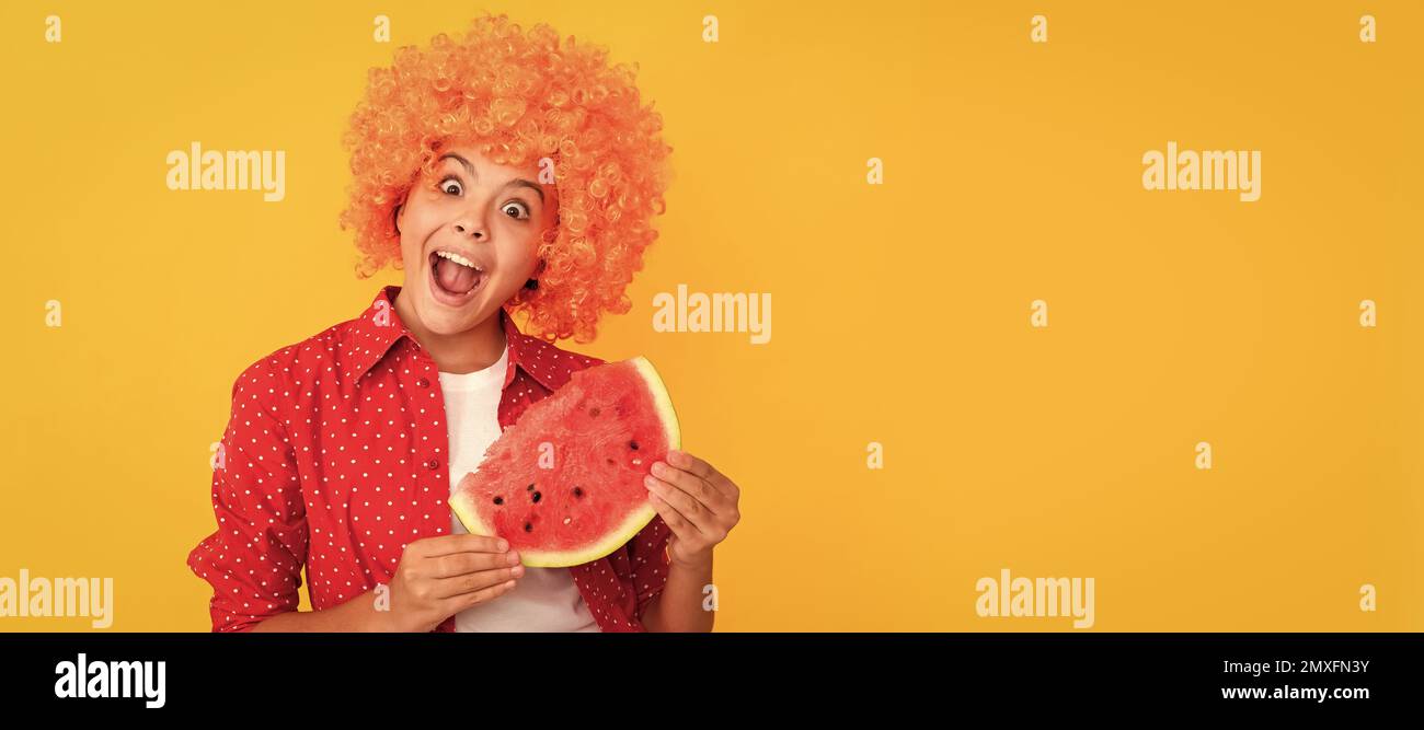 surprised kid in fancy orange hair wig holding fresh ripe water melon ...