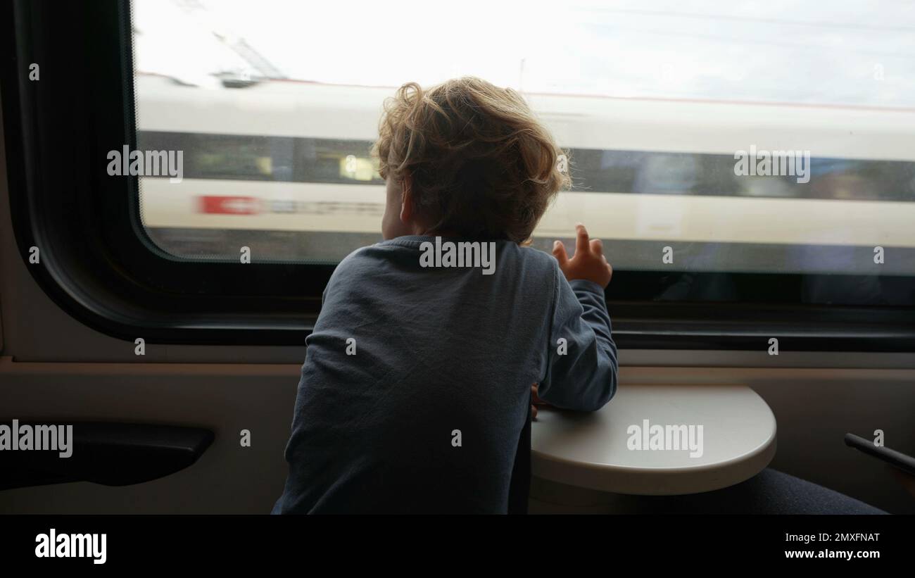 Boy looking through window while traveling train hi-res stock ...