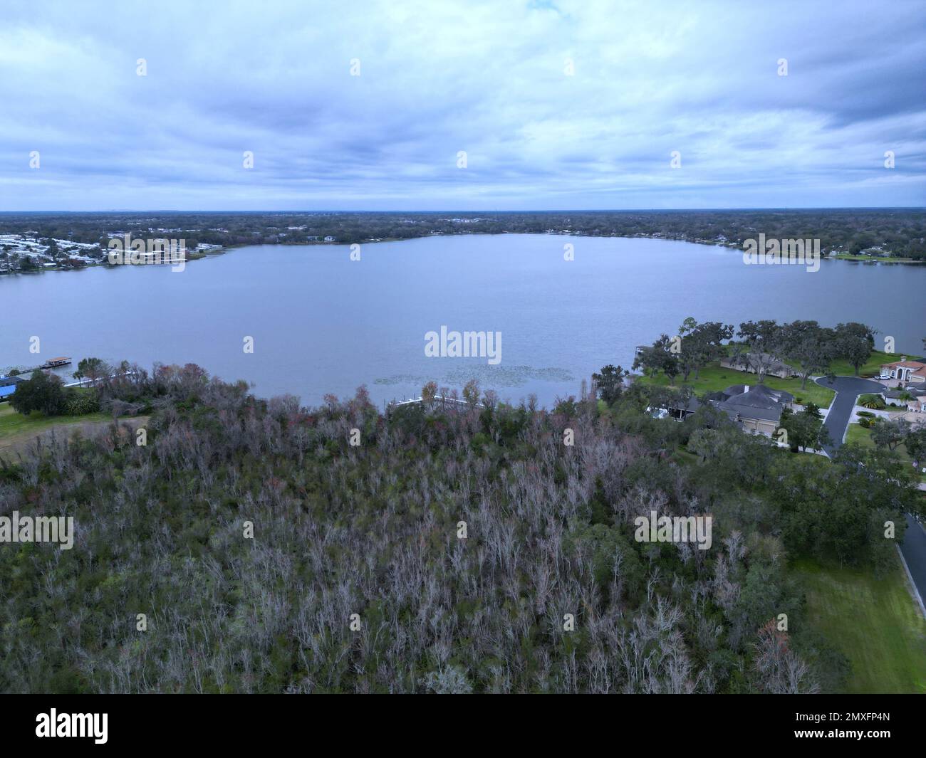 An aerial view of a lake surrounded by trees and houses in Dunmanway ...