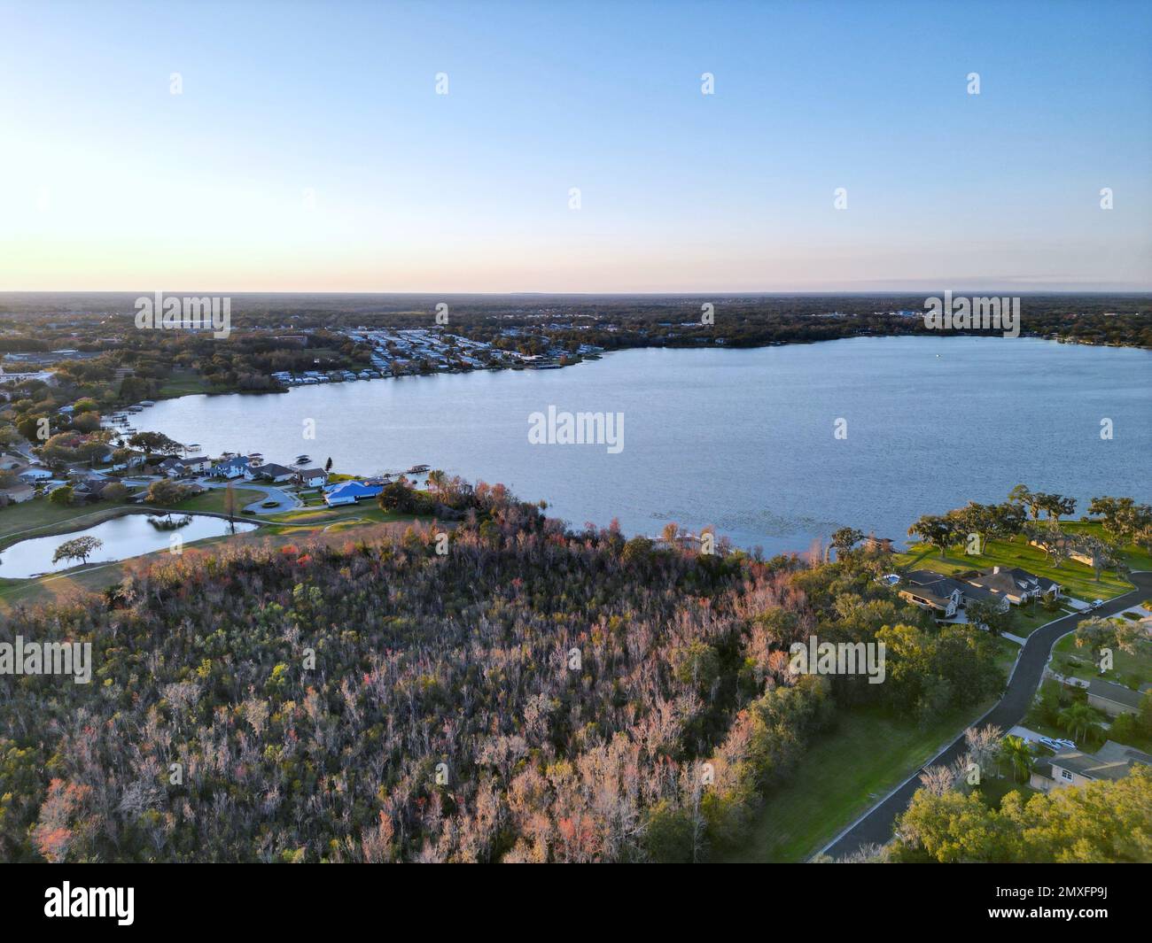 An aerial view of a lake surrounded by trees and houses in Dunmanway ...