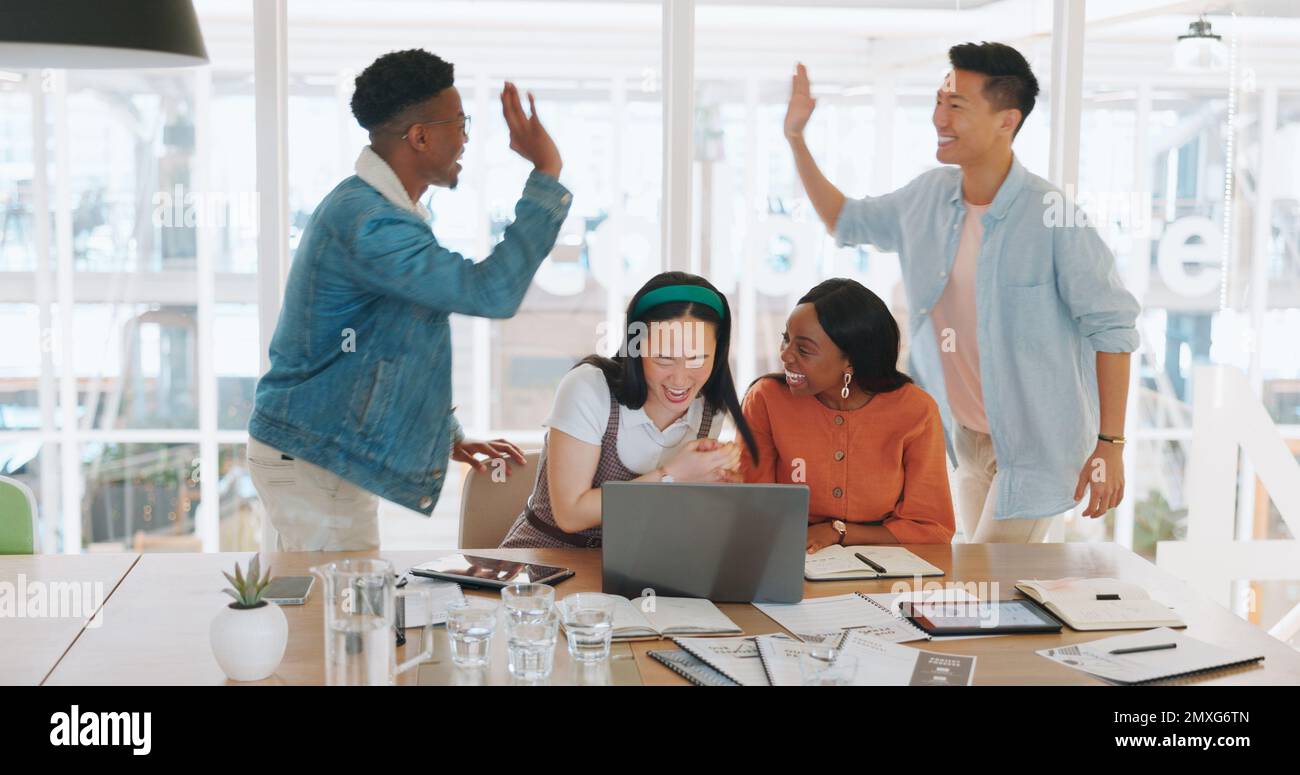 Celebration, laptop and business people high five, applause and celebrate goals, targets or ...