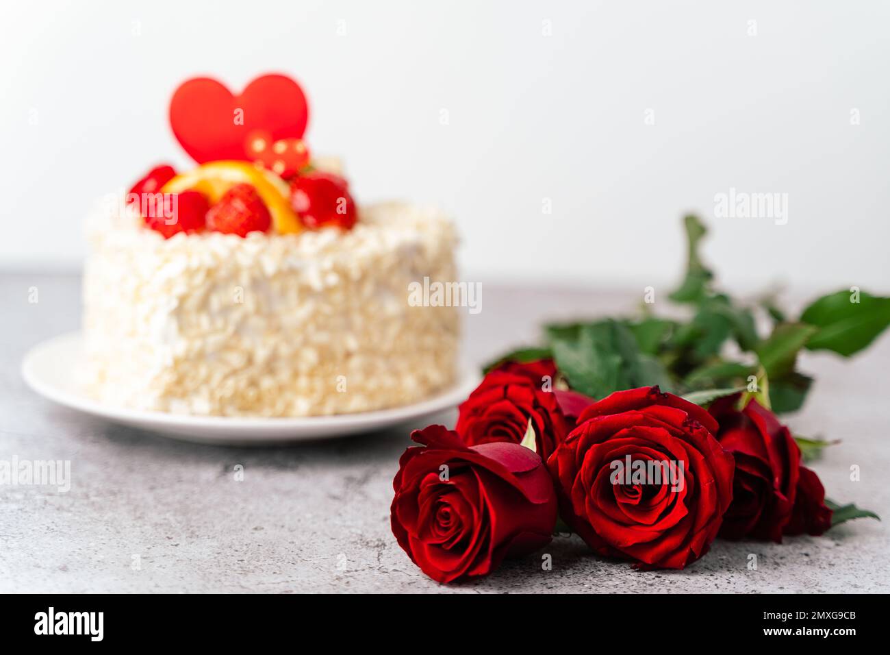 Roses flowers and Valentine's Day cake with heart shape and fruits ...