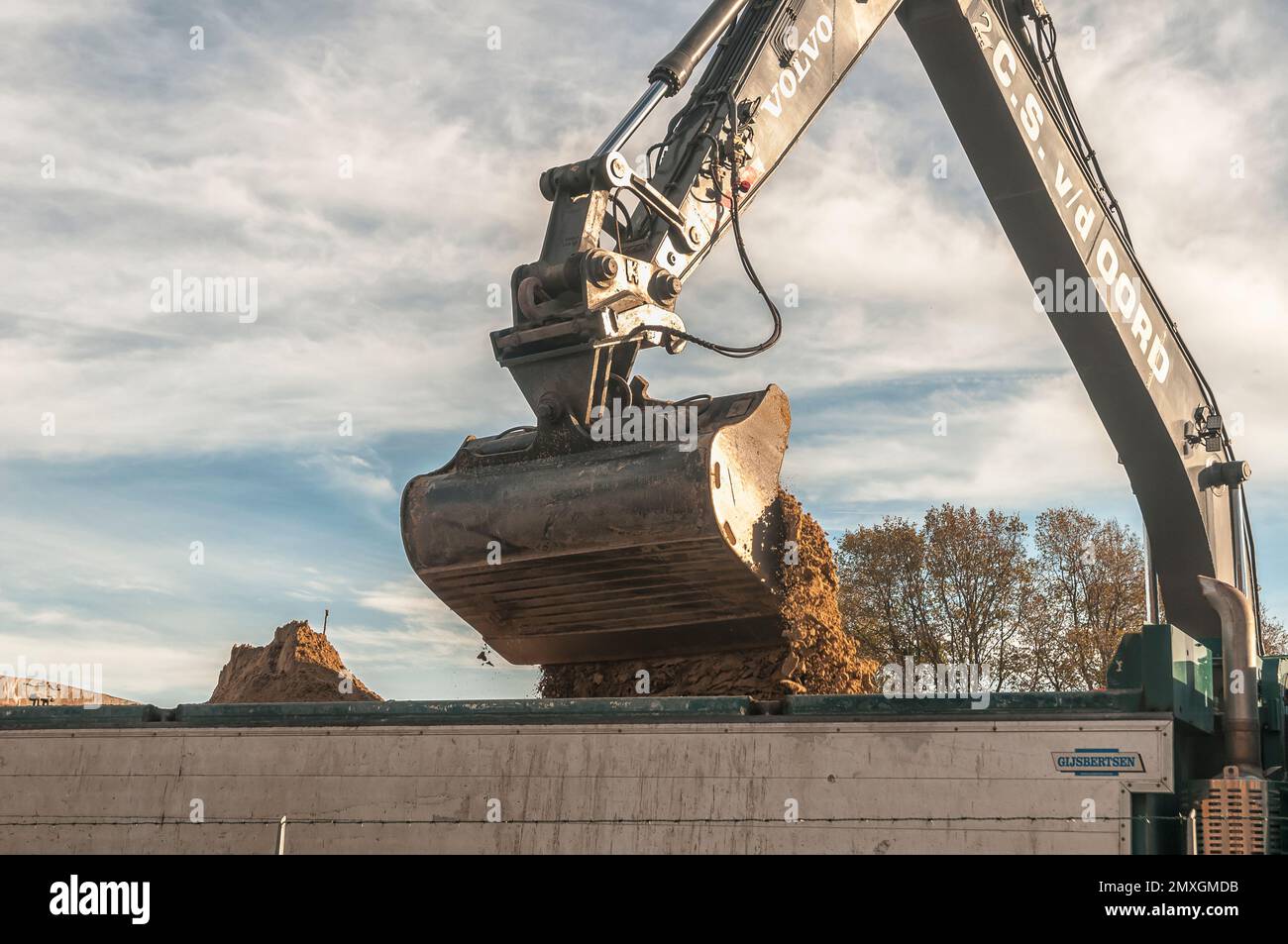 excavator unloads its sand into the back of a truck Stock Photo - Alamy