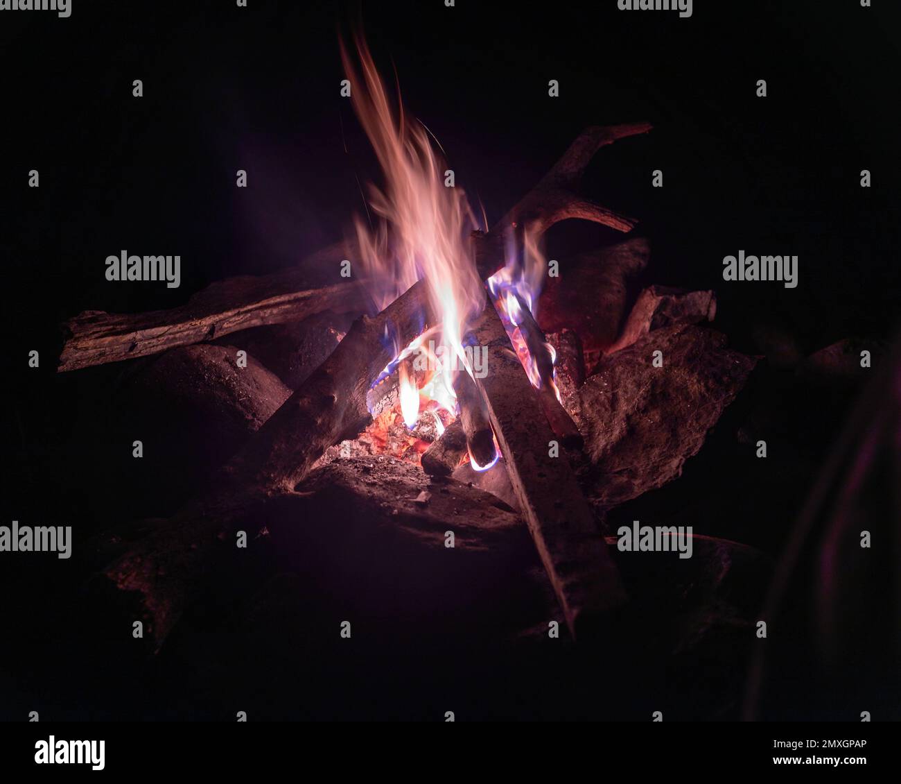 Red flame bonfire with sparks and firewood in complete darkness at ...