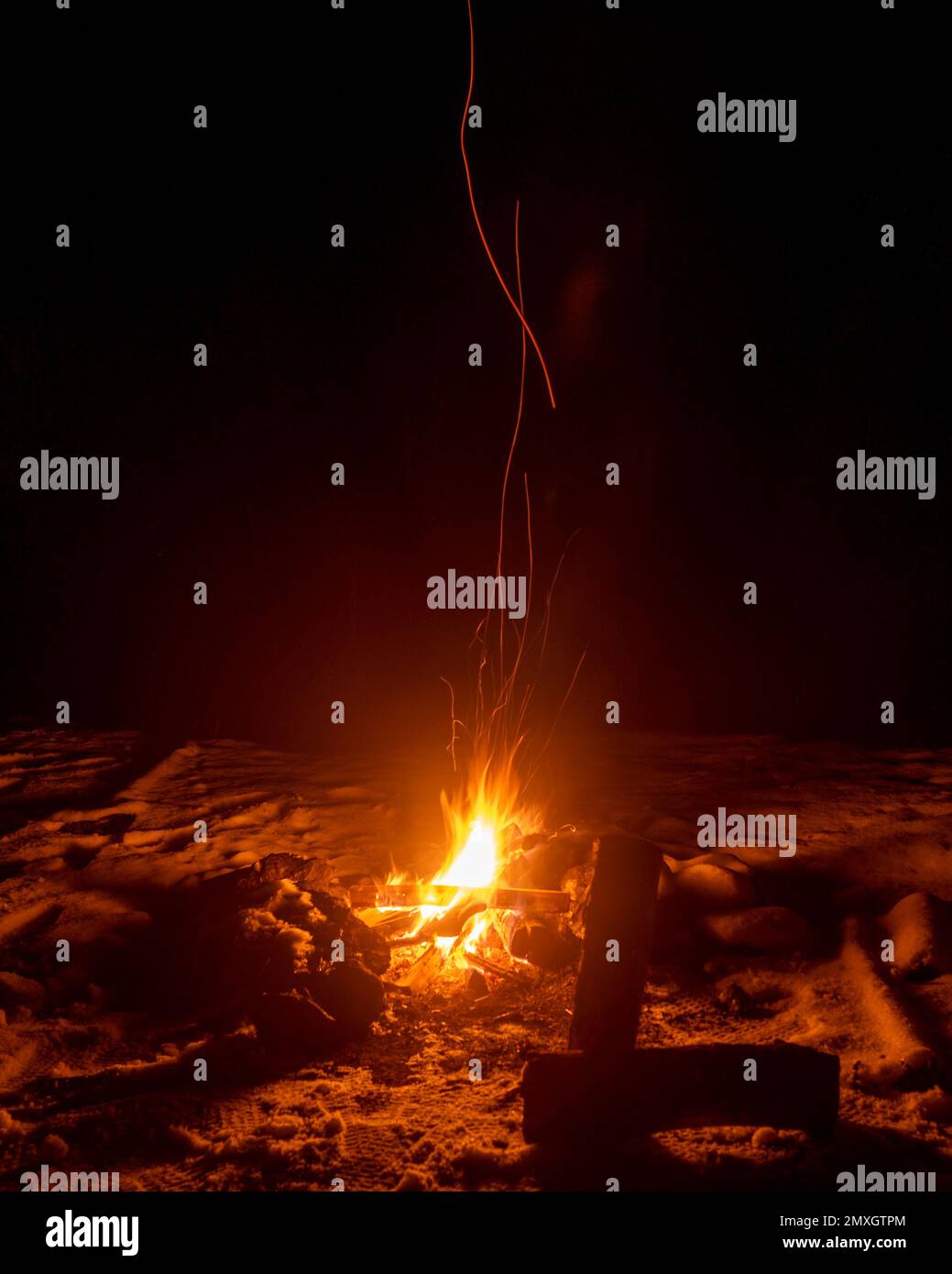 The fire burns at night in the snow. Vertical frame Stock Photo - Alamy