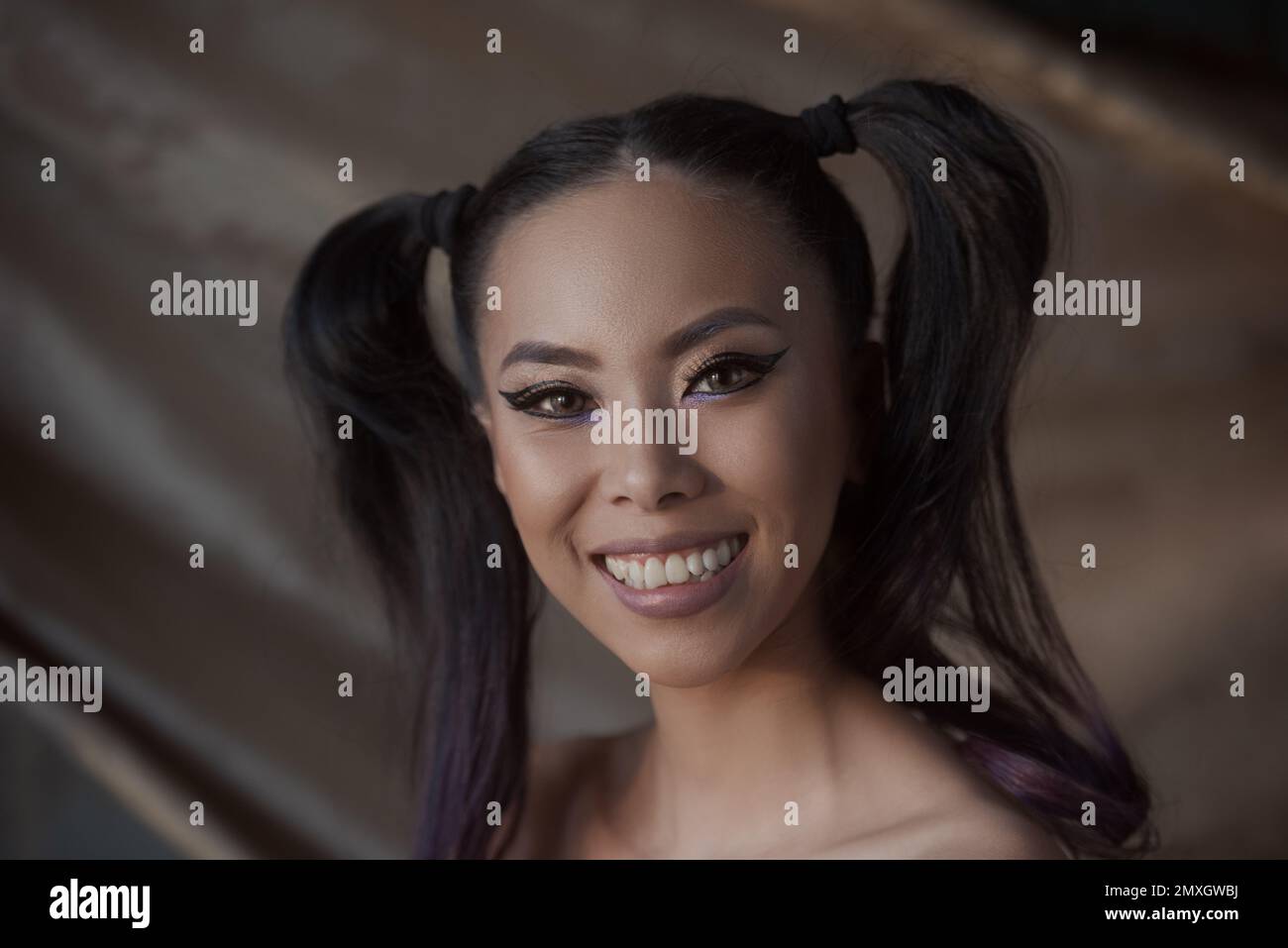 Close up portrait of young cute smiling woman with two ponytails ...