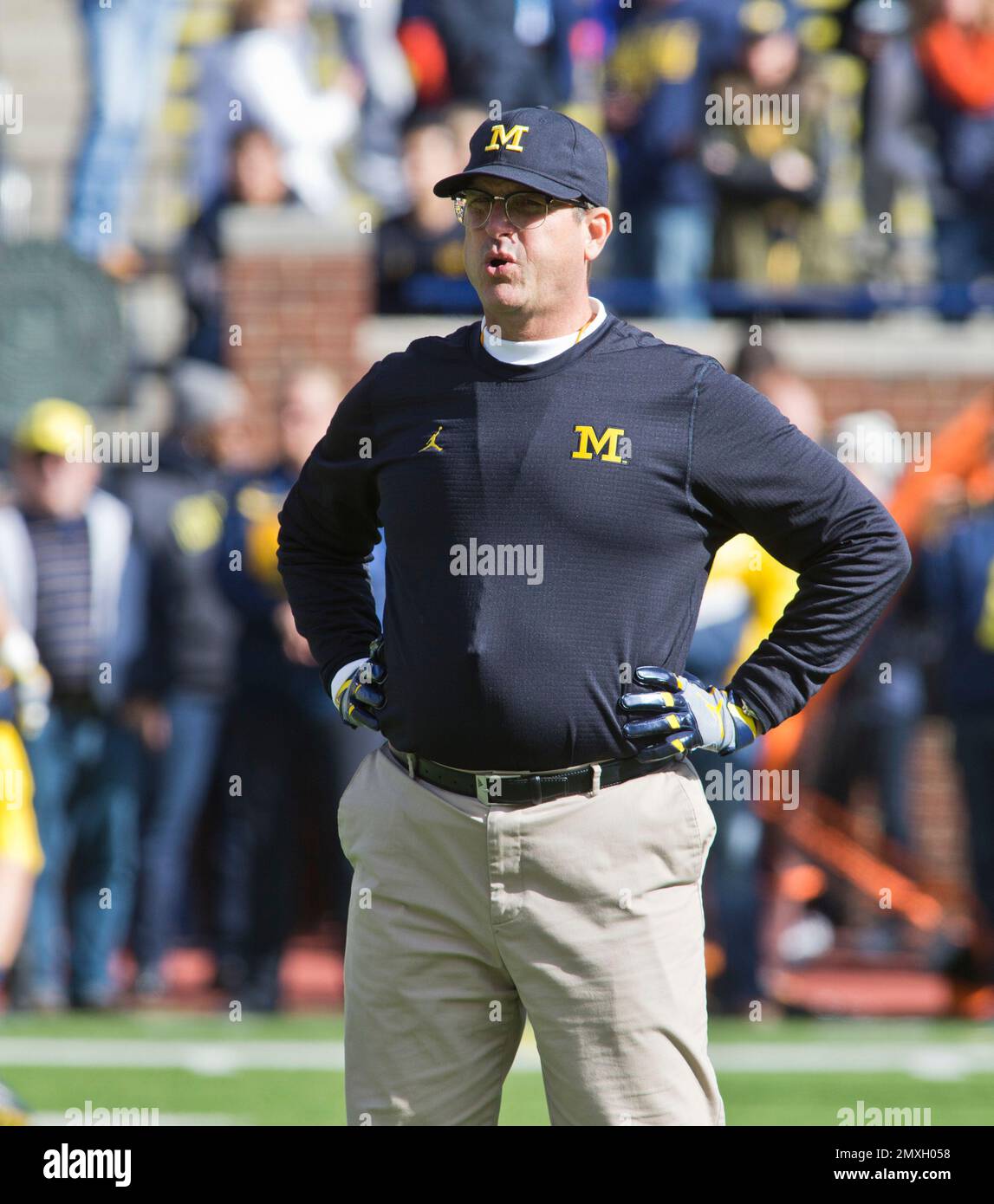 Michigan head coach Jim Harbaugh, wearing a new pair of glasses, watch ...