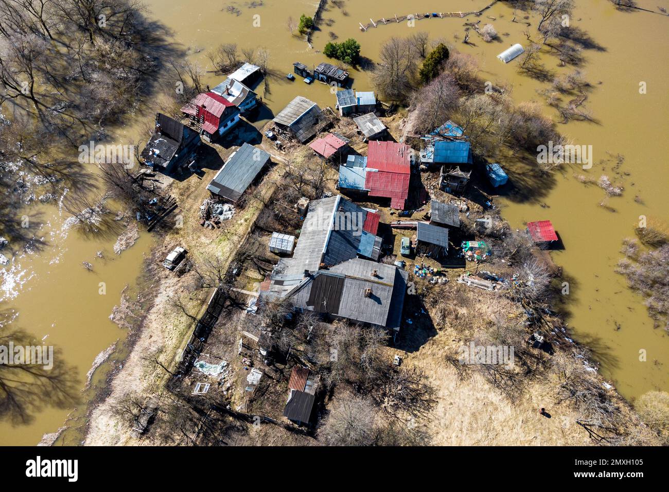 A small farm with wooden houses surrounded by water rising in the ...