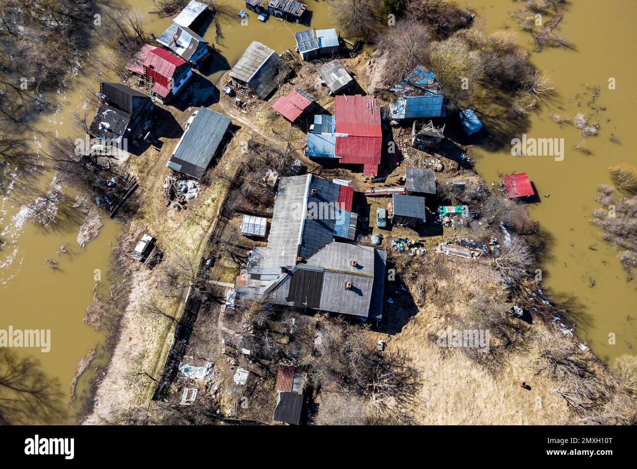 A small farm with wooden houses surrounded by water rising in the ...