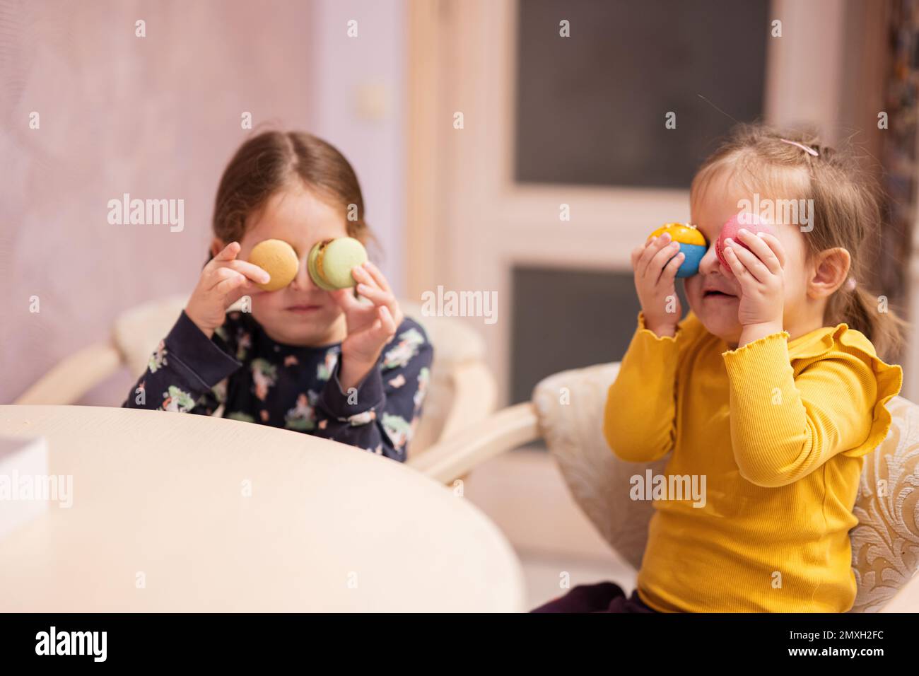 Two sisters put on eyes delicious tasty sweet color macaron Stock Photo ...