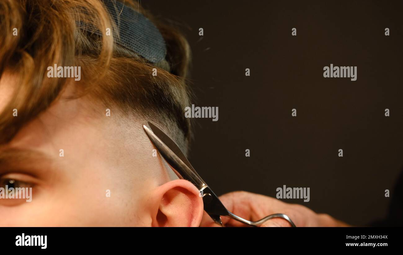 Close up Barber master hairdresser does hairstyle and style with ...