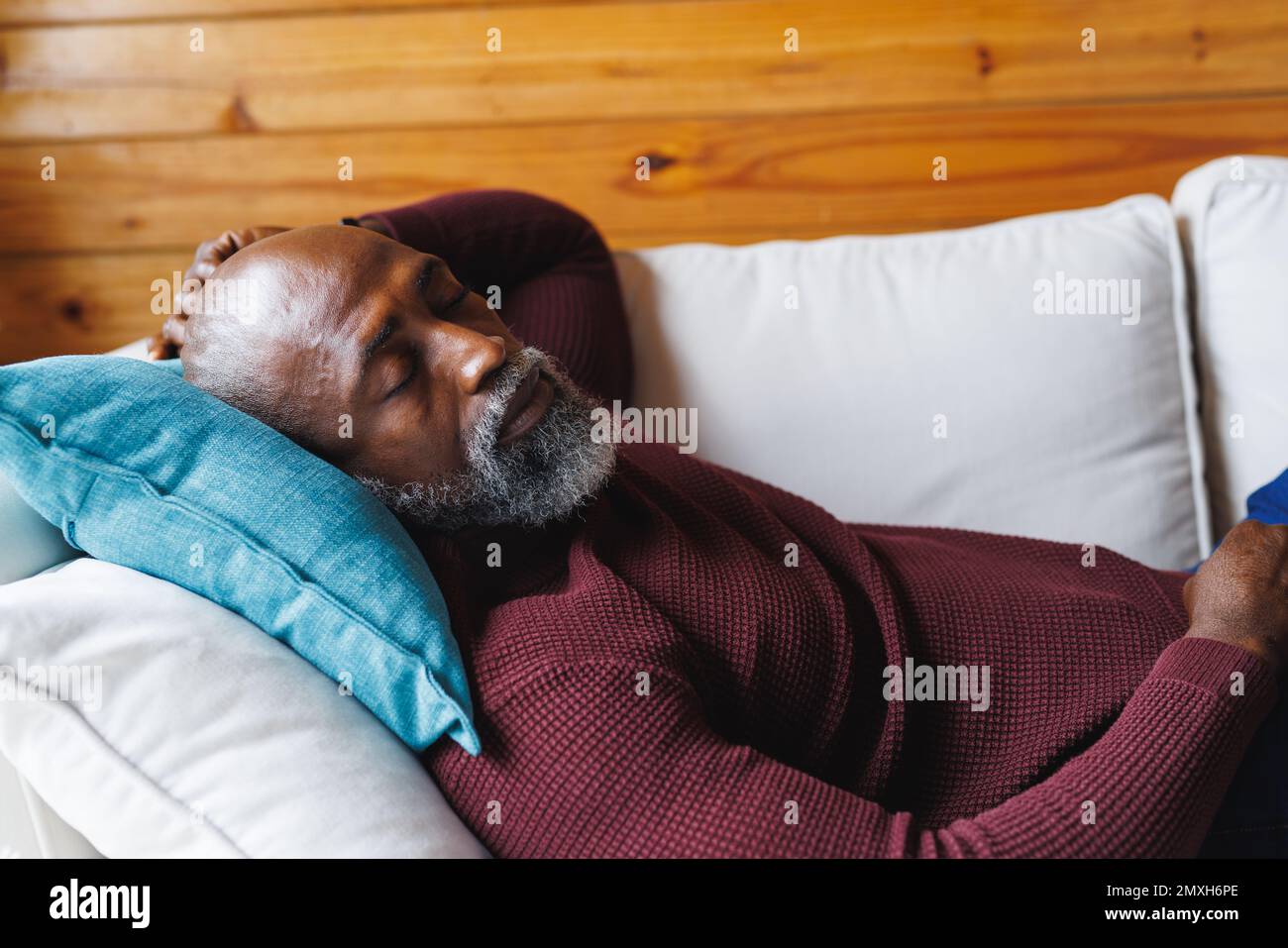 African american bald senior man sleeping on couch in log cabin Stock ...