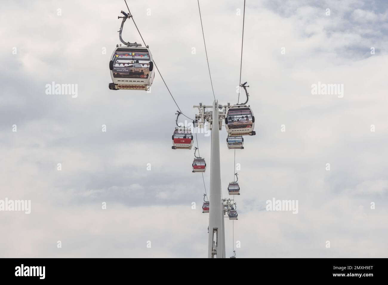 A view of gondola lifts dangling from the side of a cable in a ...