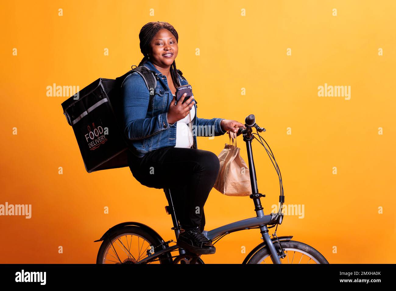 African american restaurant courier looking at client adreess on ...