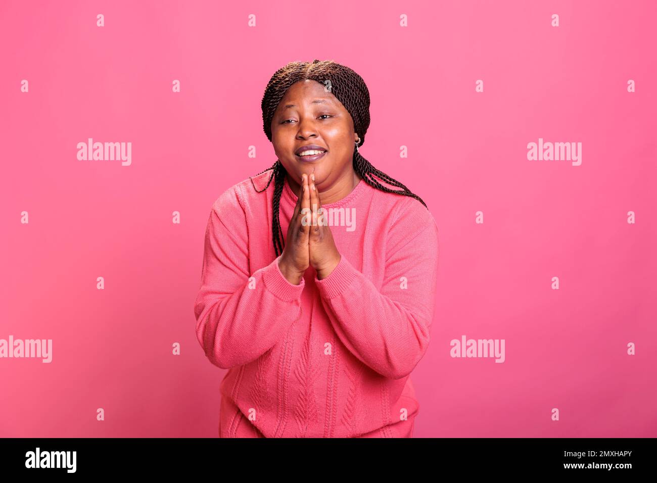 Happy female person doing prayer hands sign in studio, showing ...